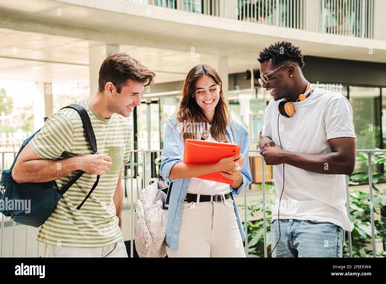 Happy multiethnic group of teenage students talking about the homeworks ...