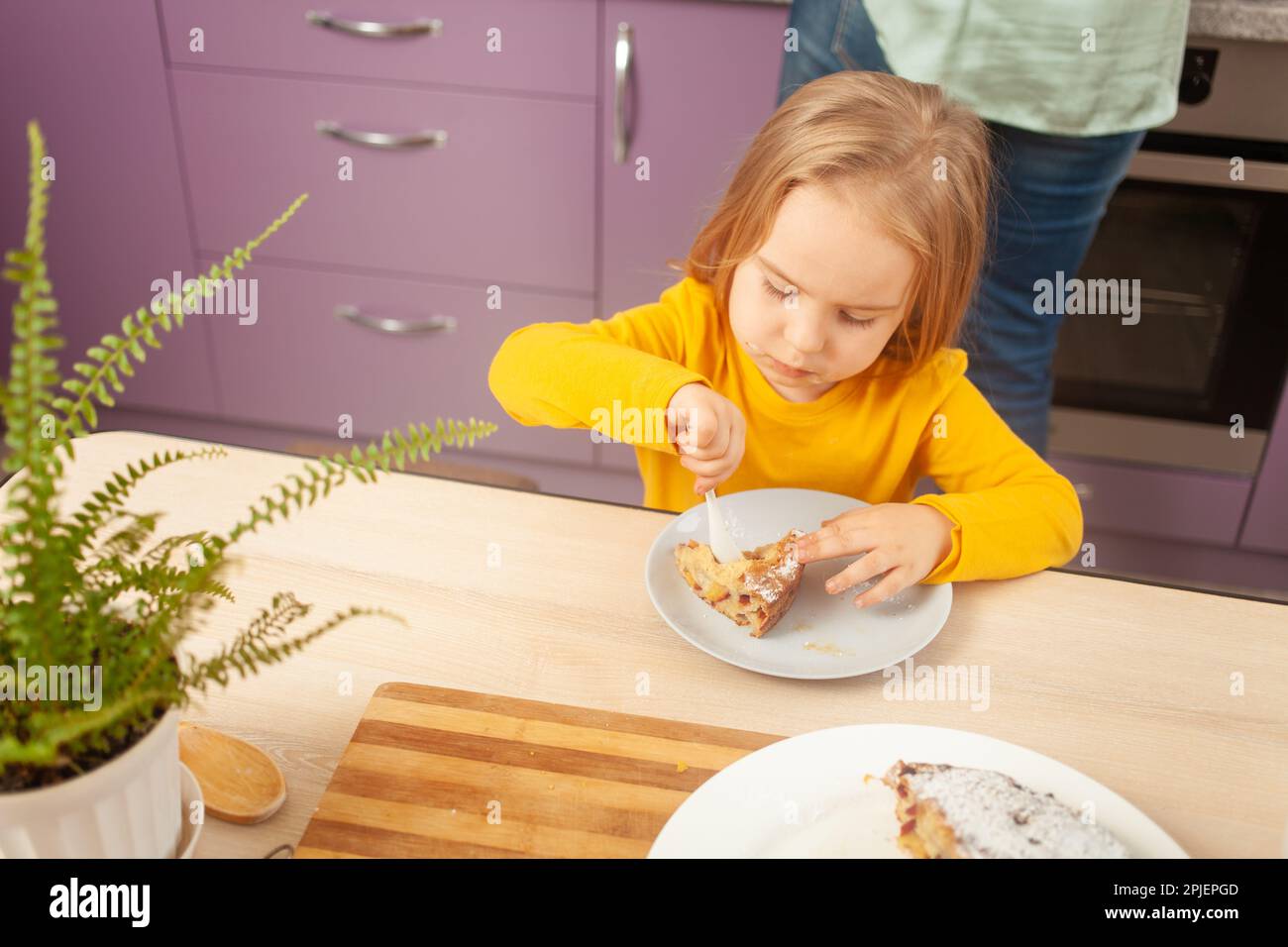 Portrait of little girl of three years old, kitchen, pie, dabbling ...