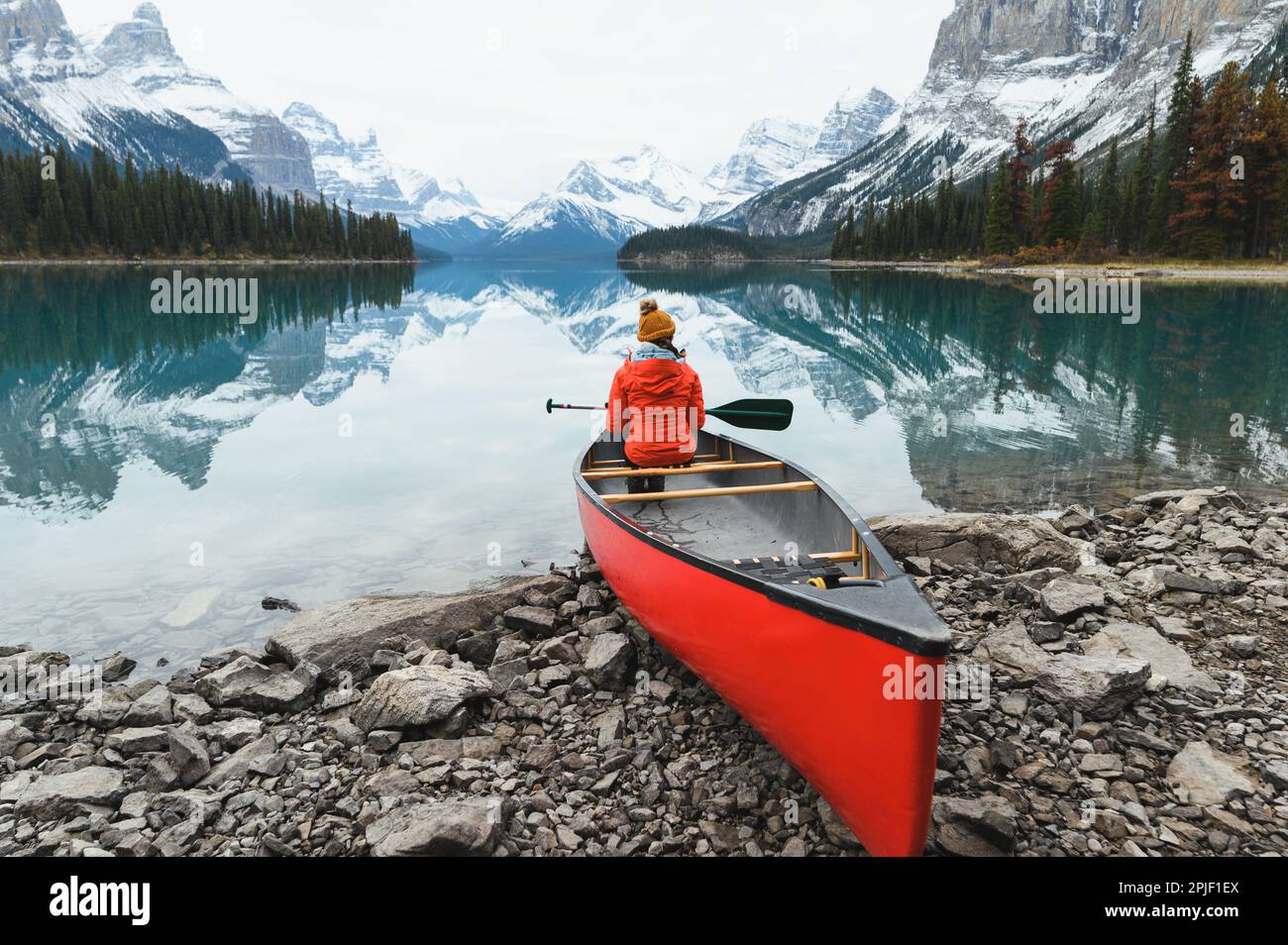 Scenery of Spirit Island with female traveler on kayak by the Maligne ...