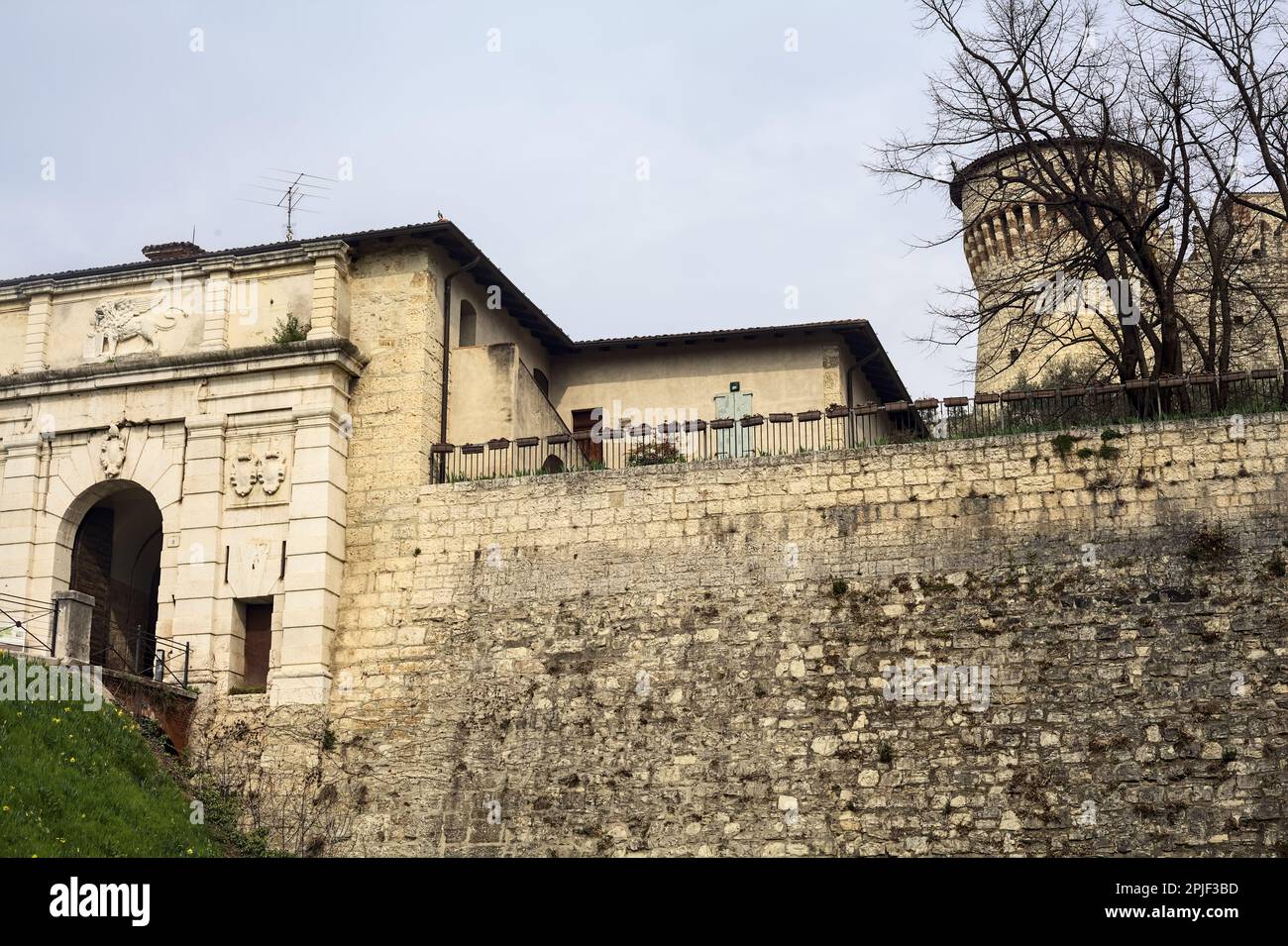 Outer boundary wall of a castle with trees and a cloudy sky as ...