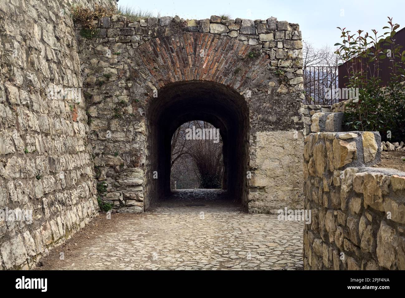 Entrance to a covered passage of a castle in a park on a cloudy day ...