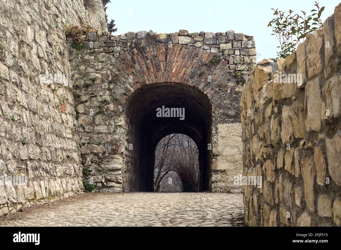 Entrance to a covered passage of a castle in a park on a cloudy day ...