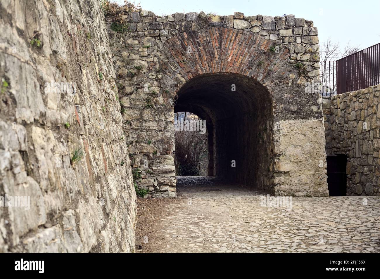 Entrance to a covered passage of a castle in a park on a cloudy day ...