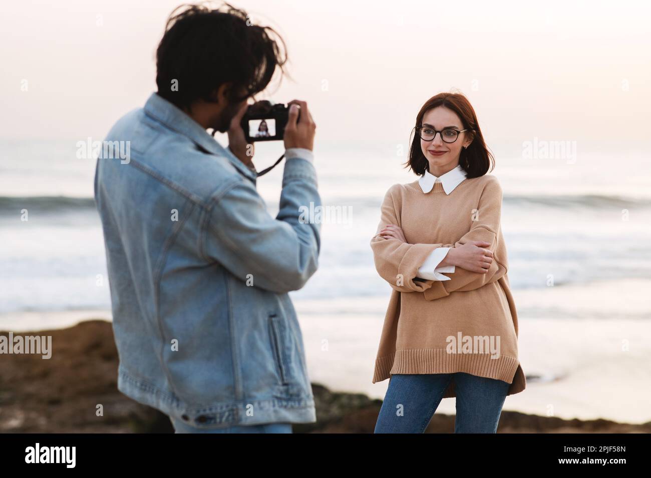 Happy young indian guy photographer in casual make photo on camera of ...