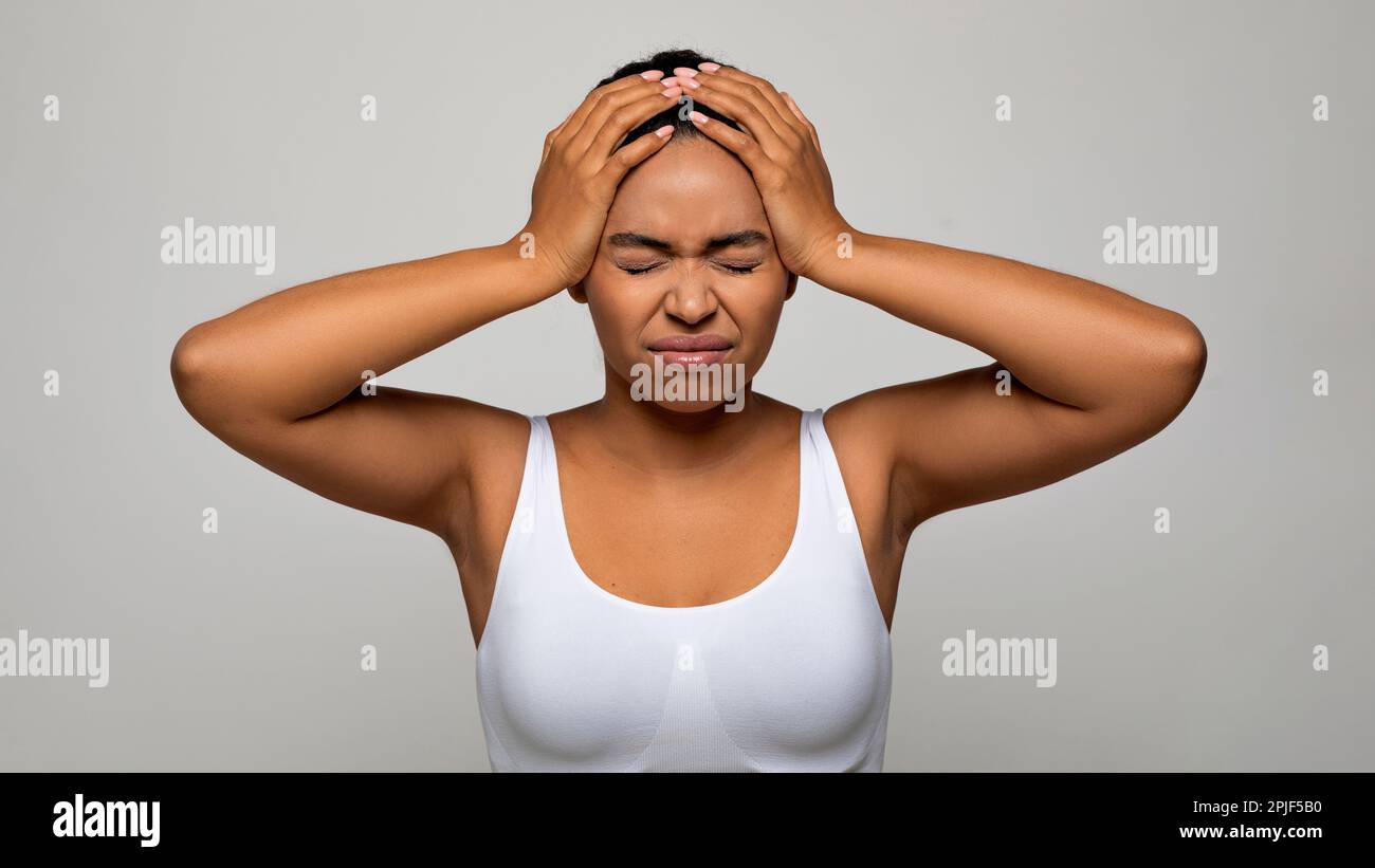 Upset african american woman suffering from terrible strong head pain ...