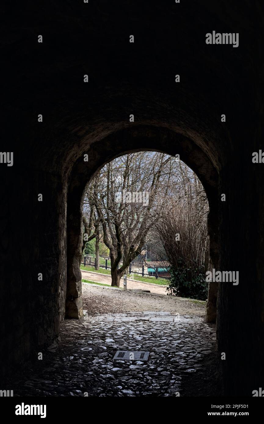 Dark and covered passage in the boundary wall of a castle Stock Photo ...