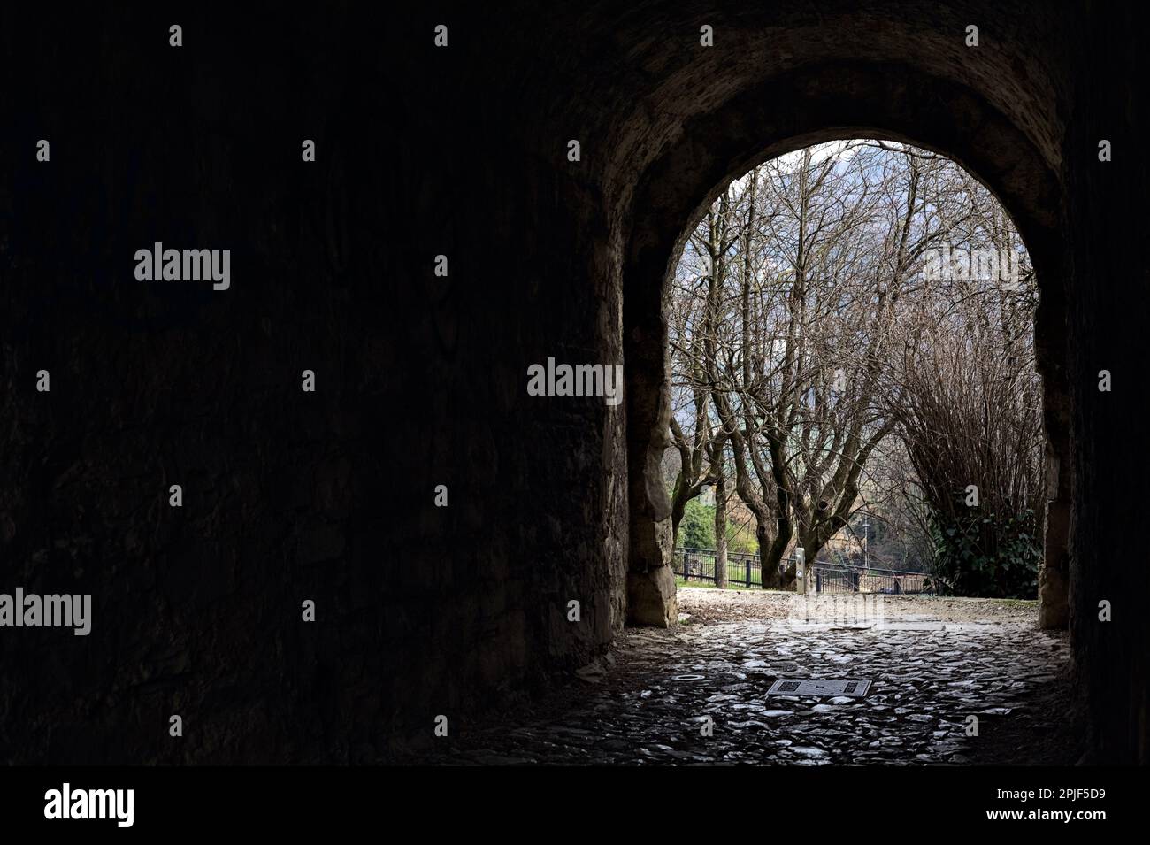 Dark and covered passage in the boundary wall of a castle Stock Photo ...