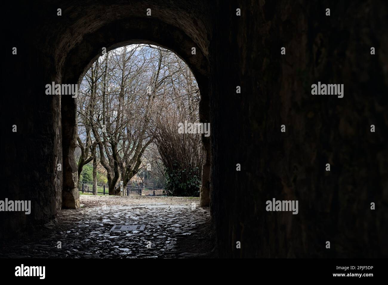 Dark and covered passage in the boundary wall of a castle Stock Photo ...