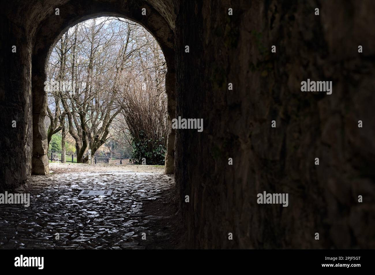 Dark and covered passage in the boundary wall of a castle Stock Photo ...