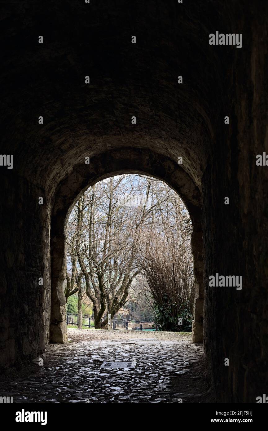 Dark and covered passage in the boundary wall of a castle Stock Photo ...