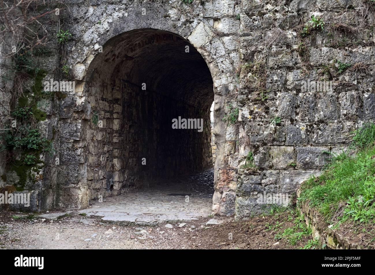 Entrance to a covered passage of a castle in a park on a cloudy day ...