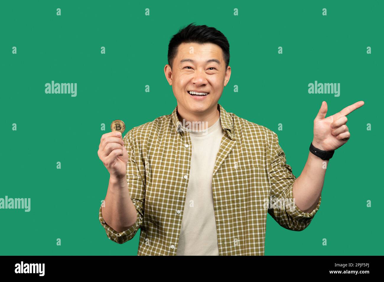 Happy asian middle aged man holding virtual currency bitcoin and ...