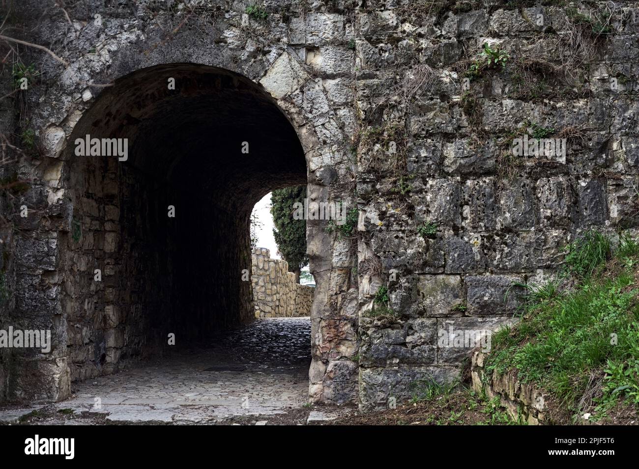 Entrance to a covered passage of a castle in a park on a cloudy day ...