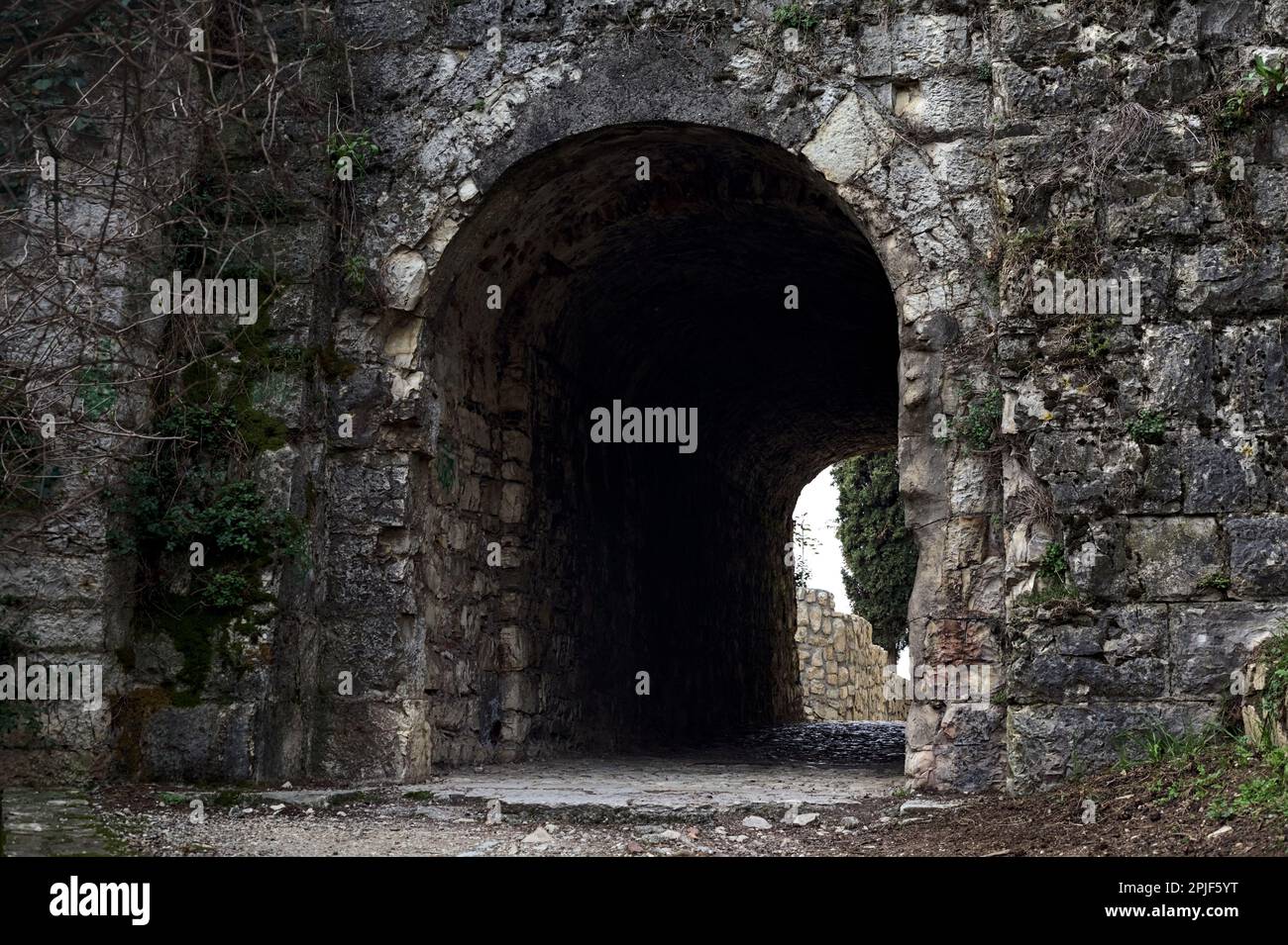 Entrance to a covered passage of a castle in a park on a cloudy day ...