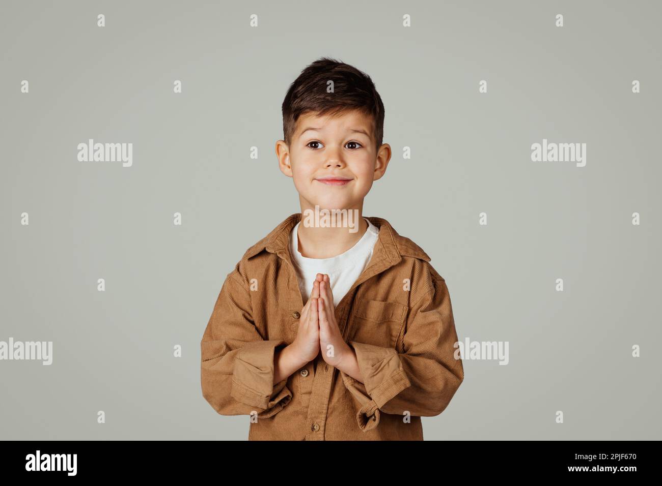 Happy cute caucasian 6 years old little boy in casual making gesture ...