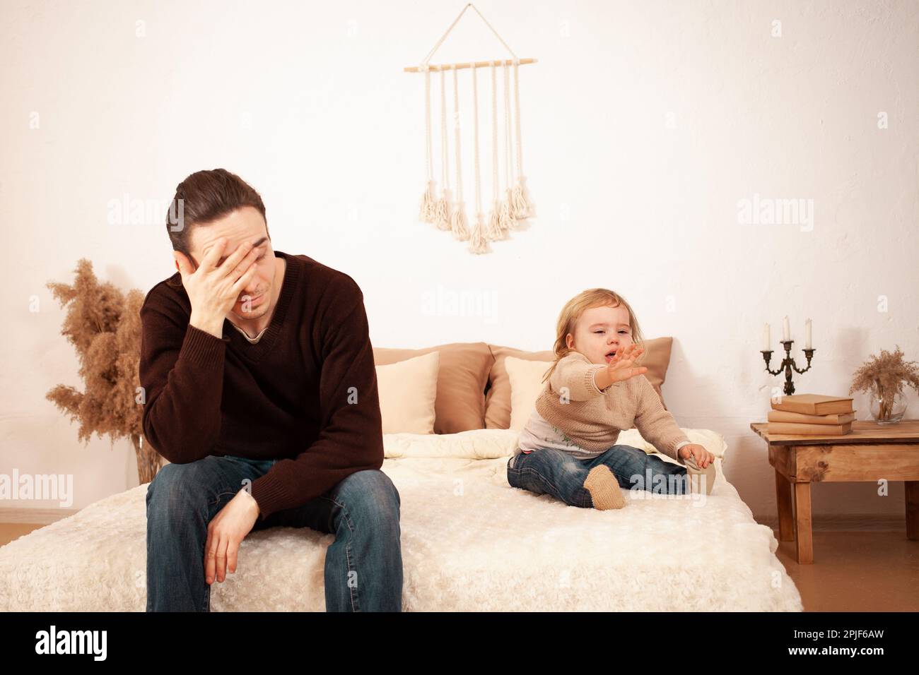 Dad can not cope with the child, a two-year-old girl lies on the bed ...