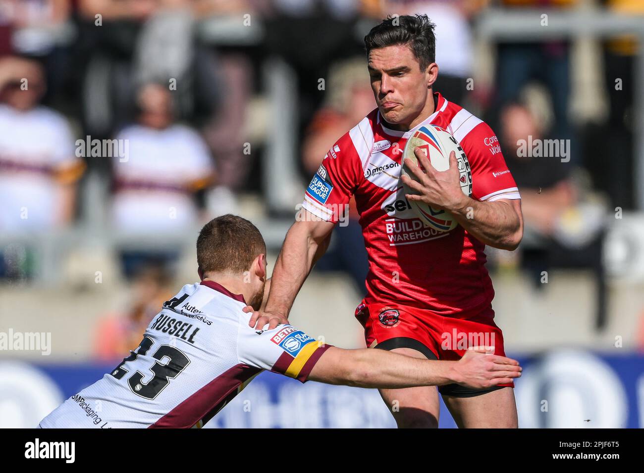 Brodie Croft #6 of Salford Red Devils is tackled by Olly Russell #23 of ...
