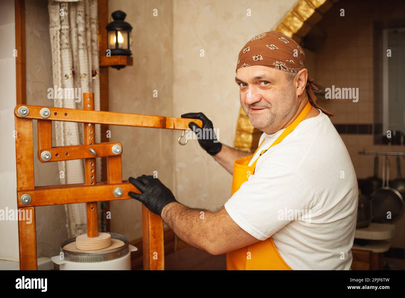 The cheesemaker puts cheese under press, whey. Home production ...