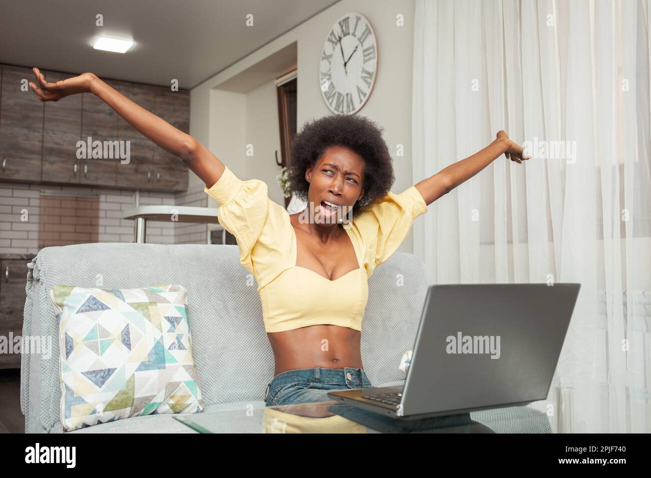 An African American woman is relaxing after work, freelancing at home ...
