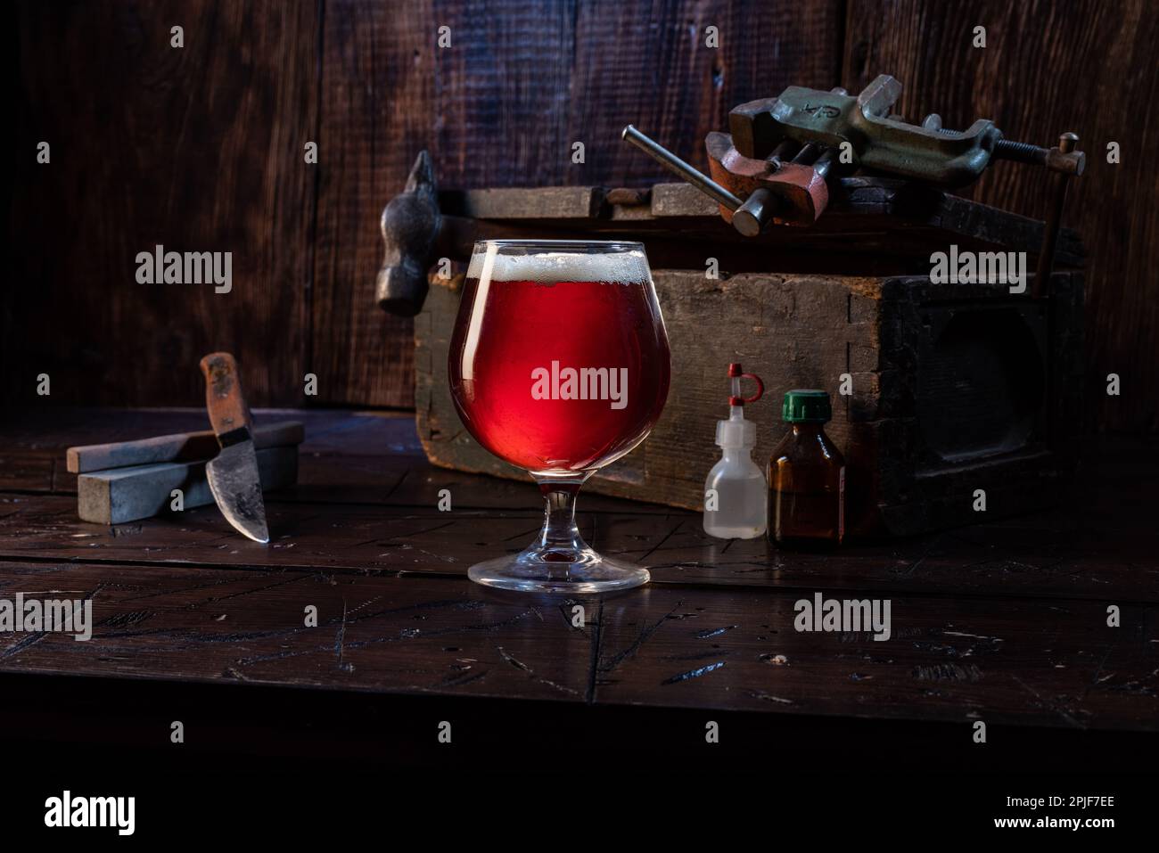 A glass of beer in the workshop. Beer after work. Beer and tools. Rest ...