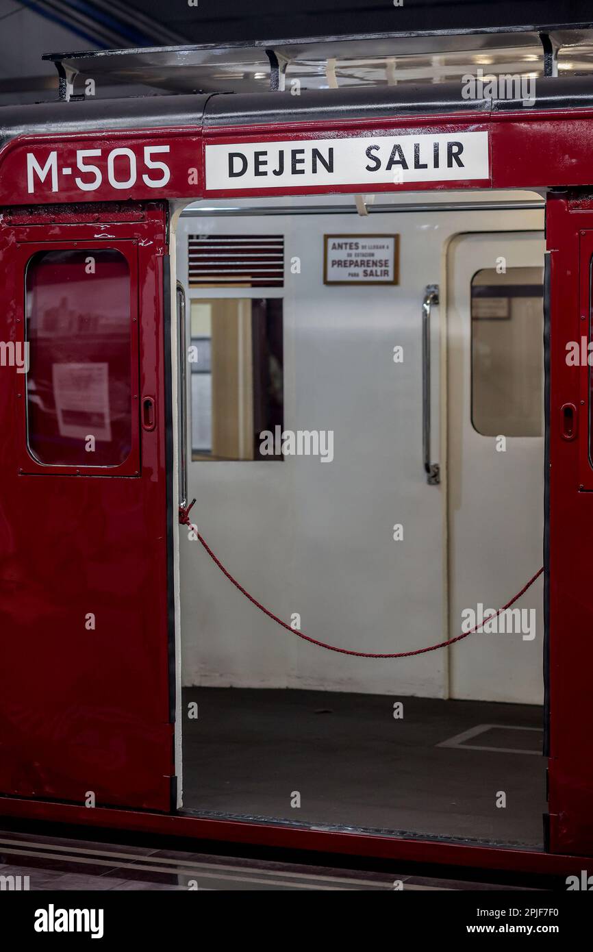 A vintage metro train carriage with the sign 'Before entering let out ...