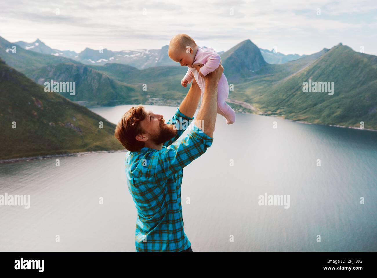 Father holding up infant baby outdoor family lifestyle traveling in ...