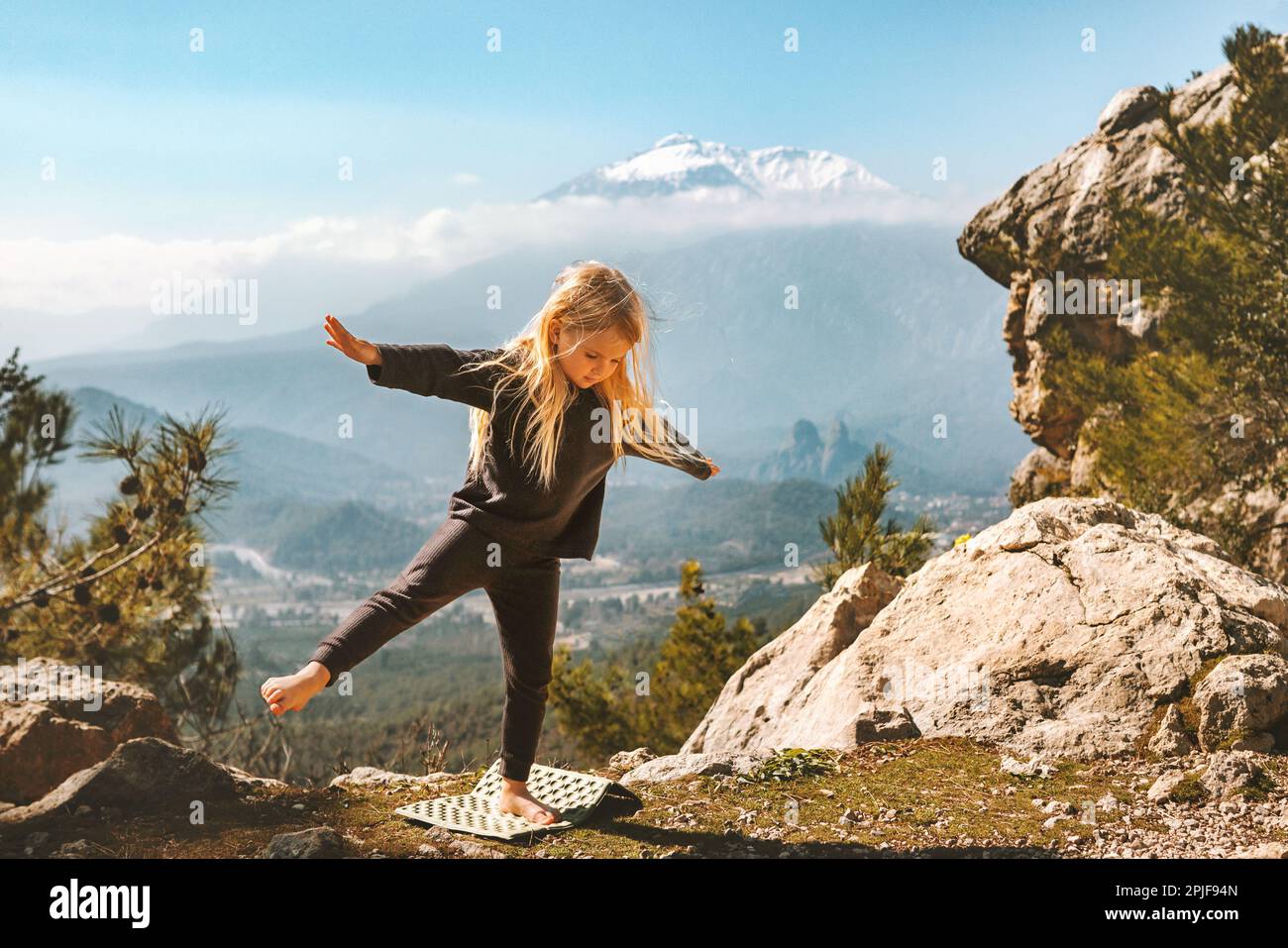 Healthy lifestyle outdoor child girl doing yoga practice in mountains ...