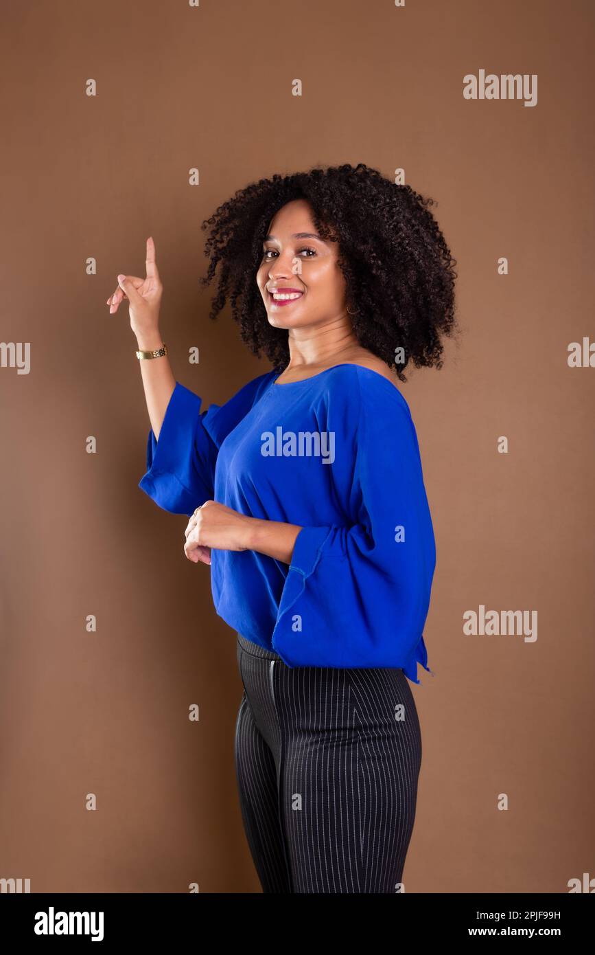 Beautiful young business woman making hand gestures. Standing against a ...
