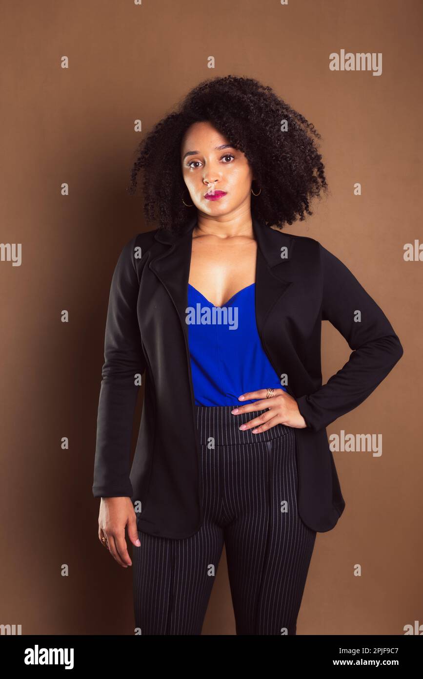 Business manager woman dressed in black blazer standing against brown ...