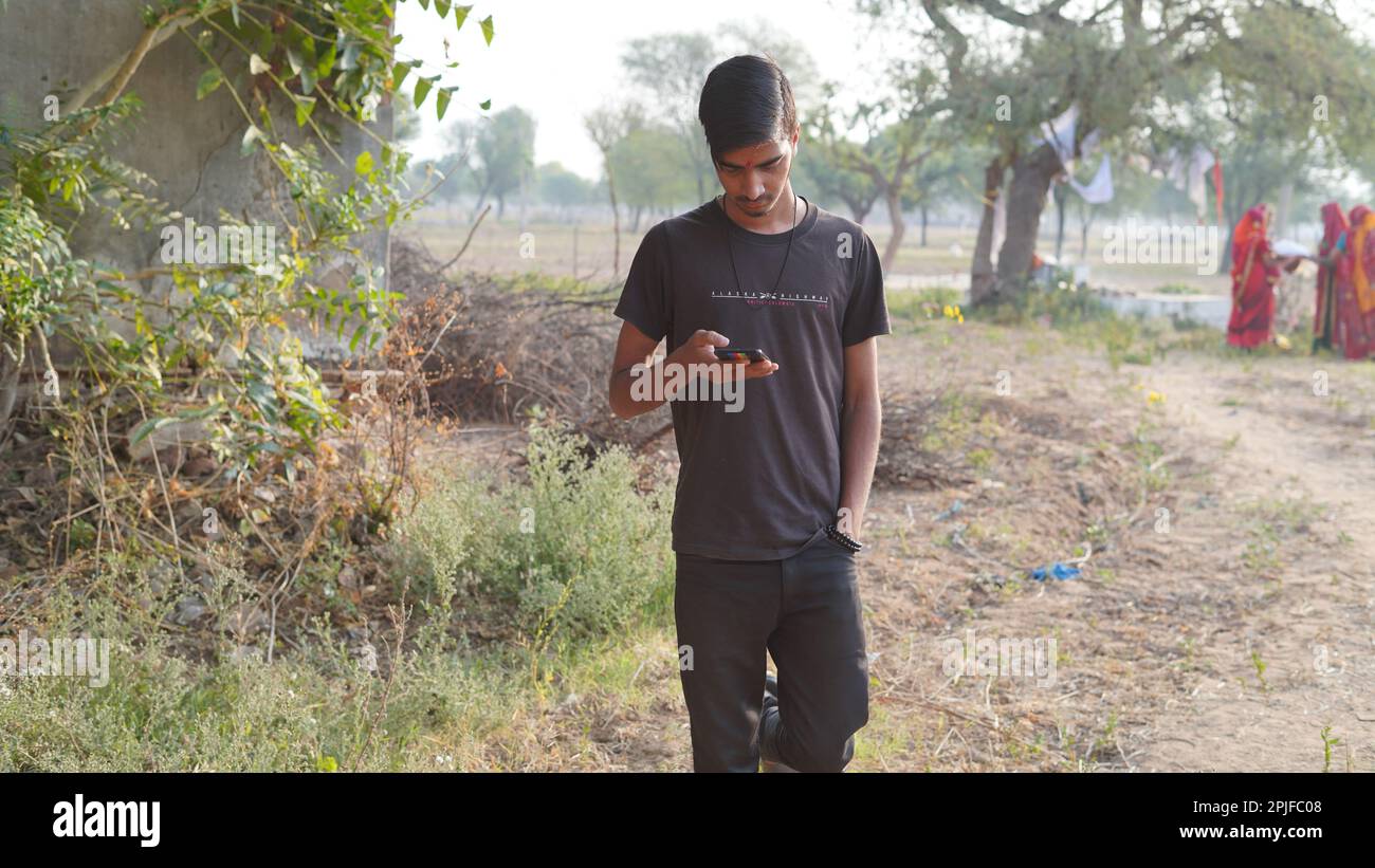 Indian Boy with serious expression using cell outdoors Stock Photo - Alamy