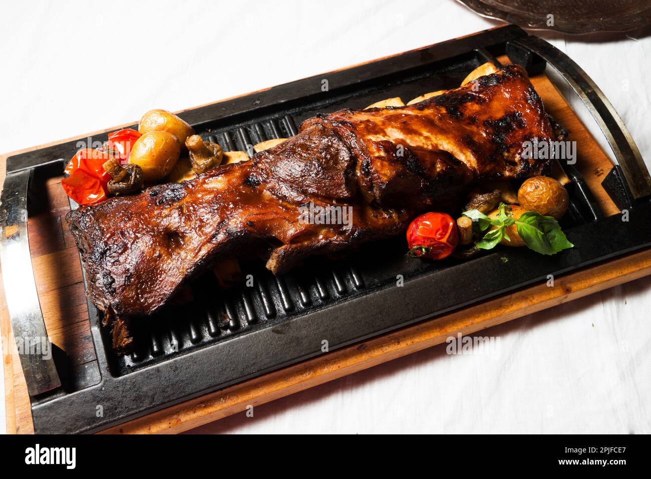 Roasted lamb leg on wooden table. Dishes from Caucasian cuisine Stock ...
