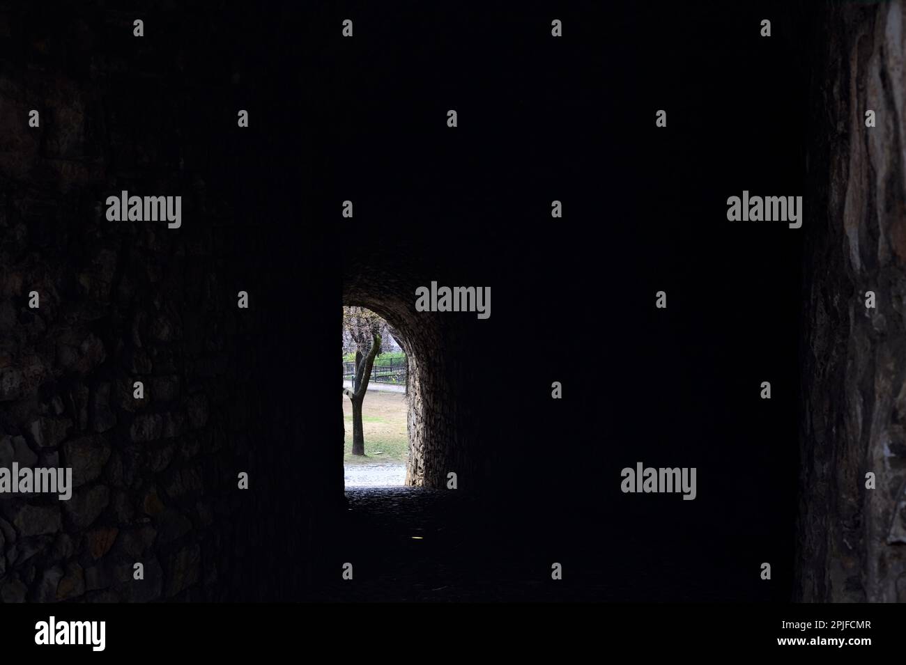 Dark and covered passage in the boundary wall of a castle Stock Photo ...