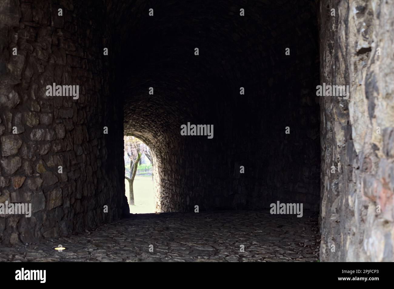 Dark and covered passage in the boundary wall of a castle Stock Photo ...