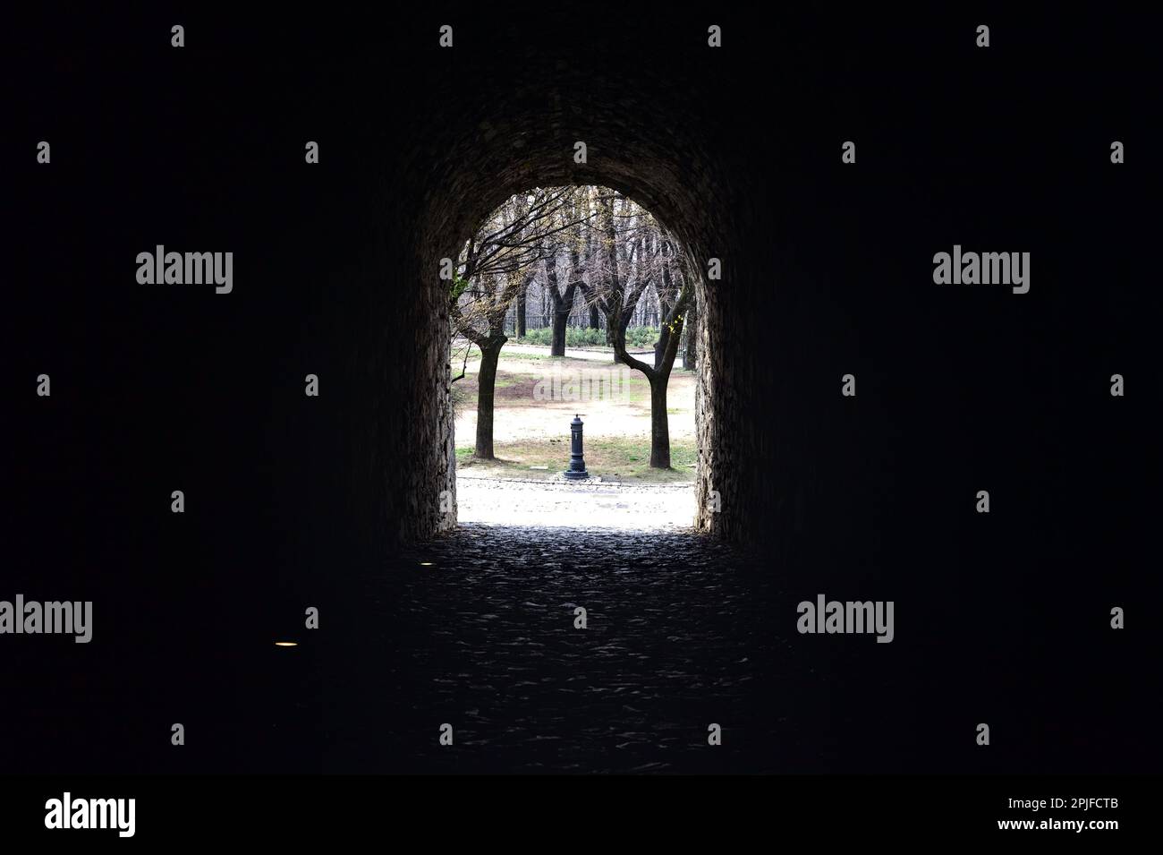 Dark and covered passage in the boundary wall of a castle Stock Photo ...