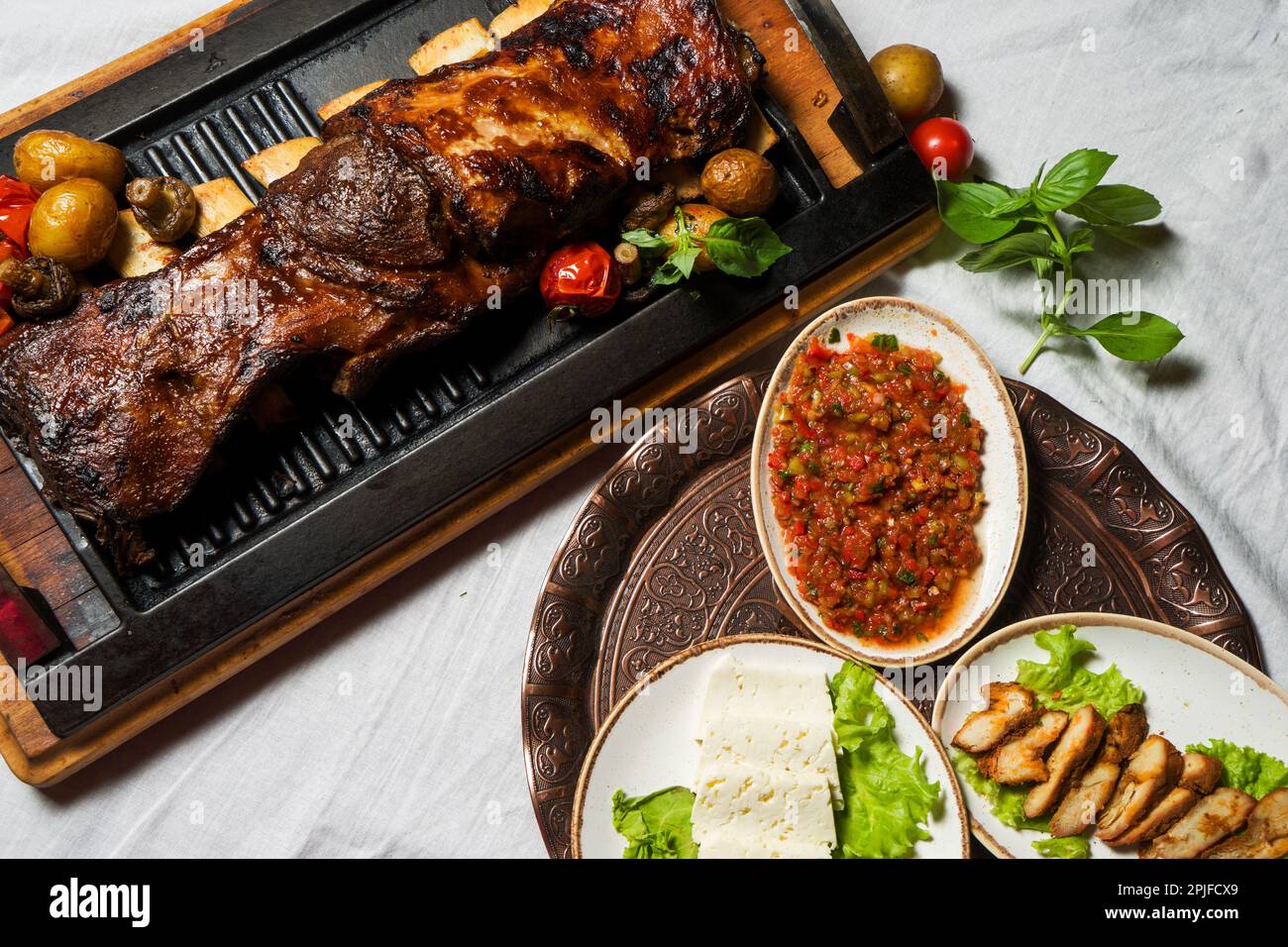 Roasted lamb leg on wooden table. Dishes from Caucasian cuisine Stock ...