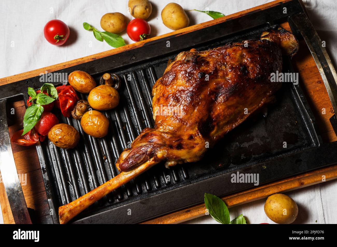 Roasted lamb leg on wooden table. Dishes from Caucasian cuisine Stock ...