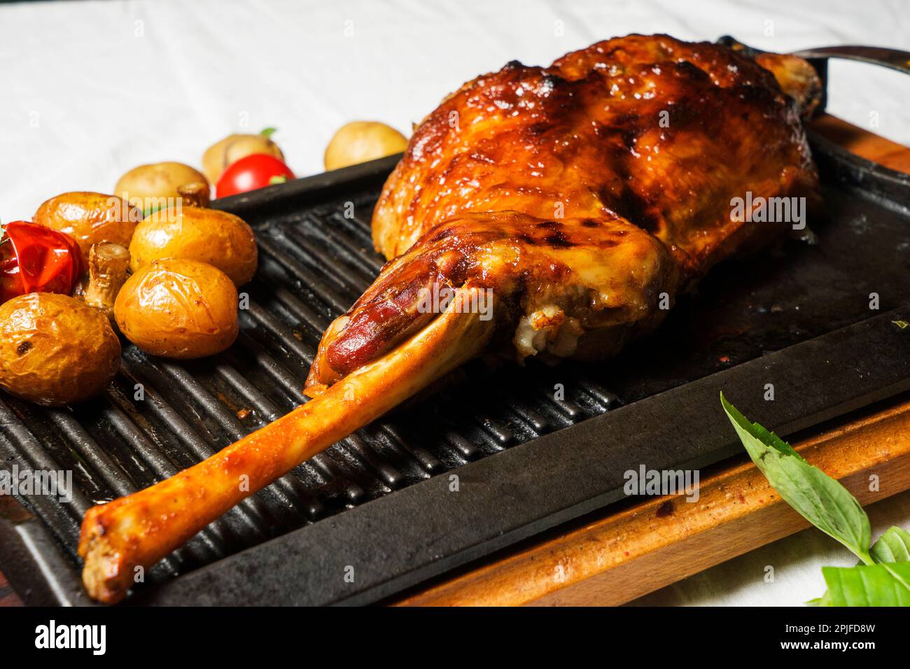 Roasted lamb leg on wooden table. Dishes from Caucasian cuisine Stock ...