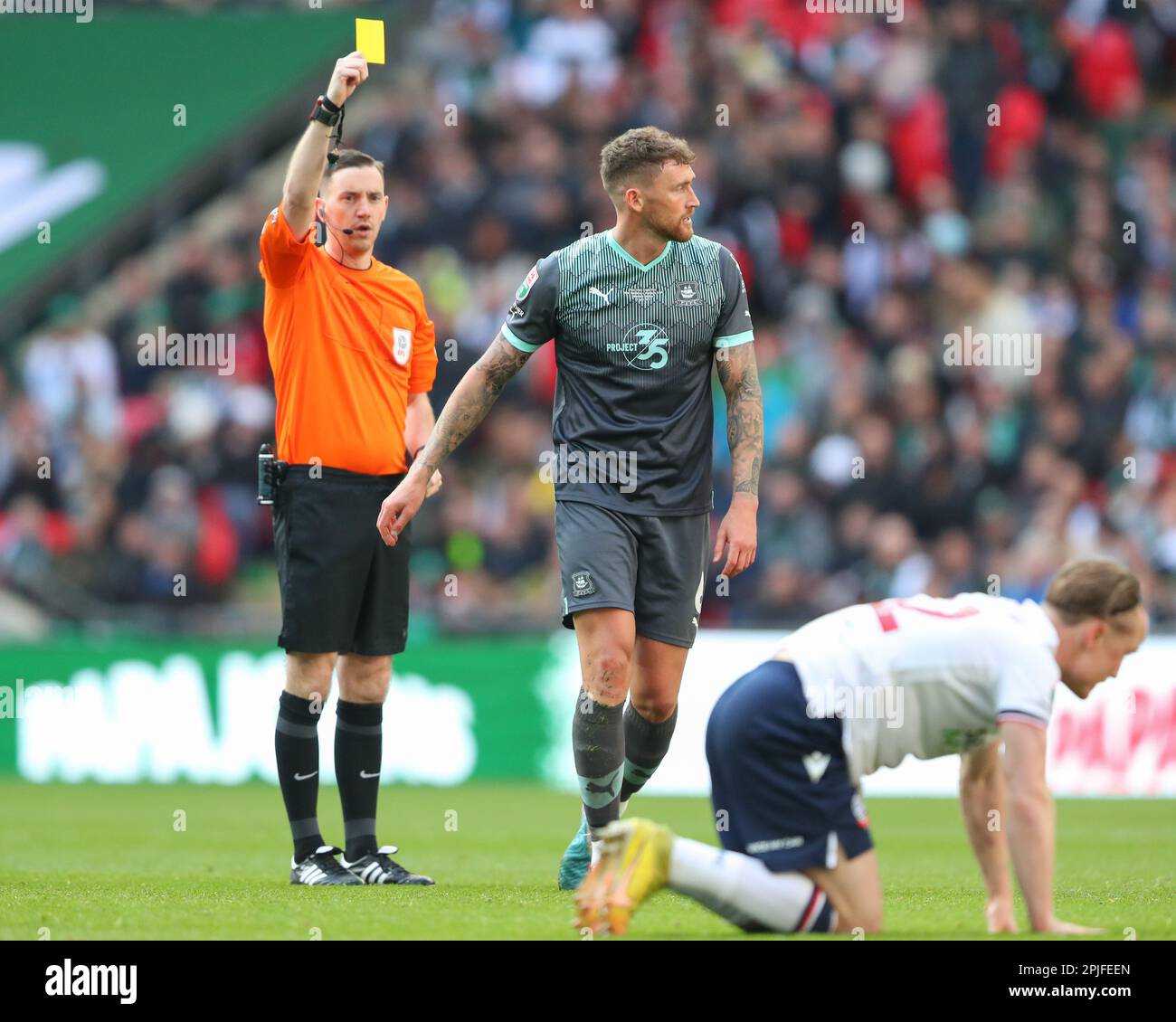 Dan Scarr #6 of Plymouth Argyle receives a yellow card from referee Ben ...