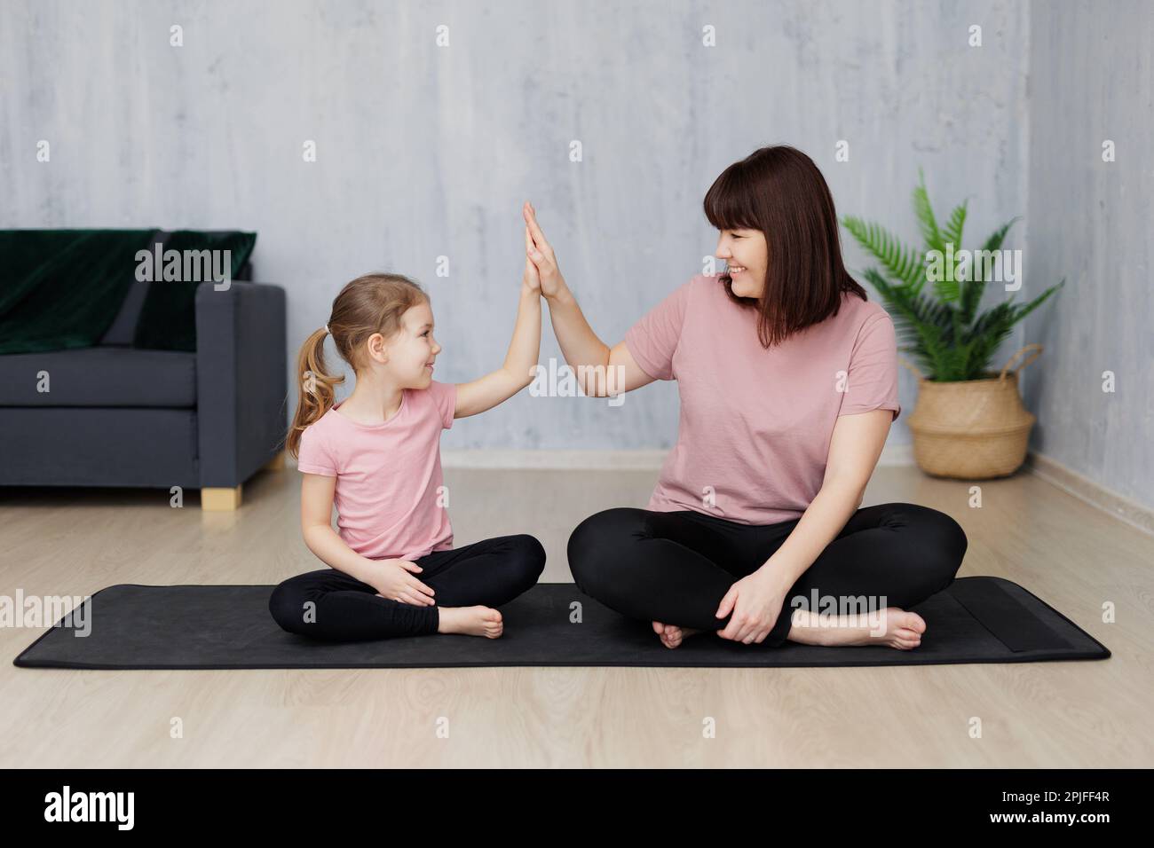 family and sport concept - young mother and little girl doing sport ...