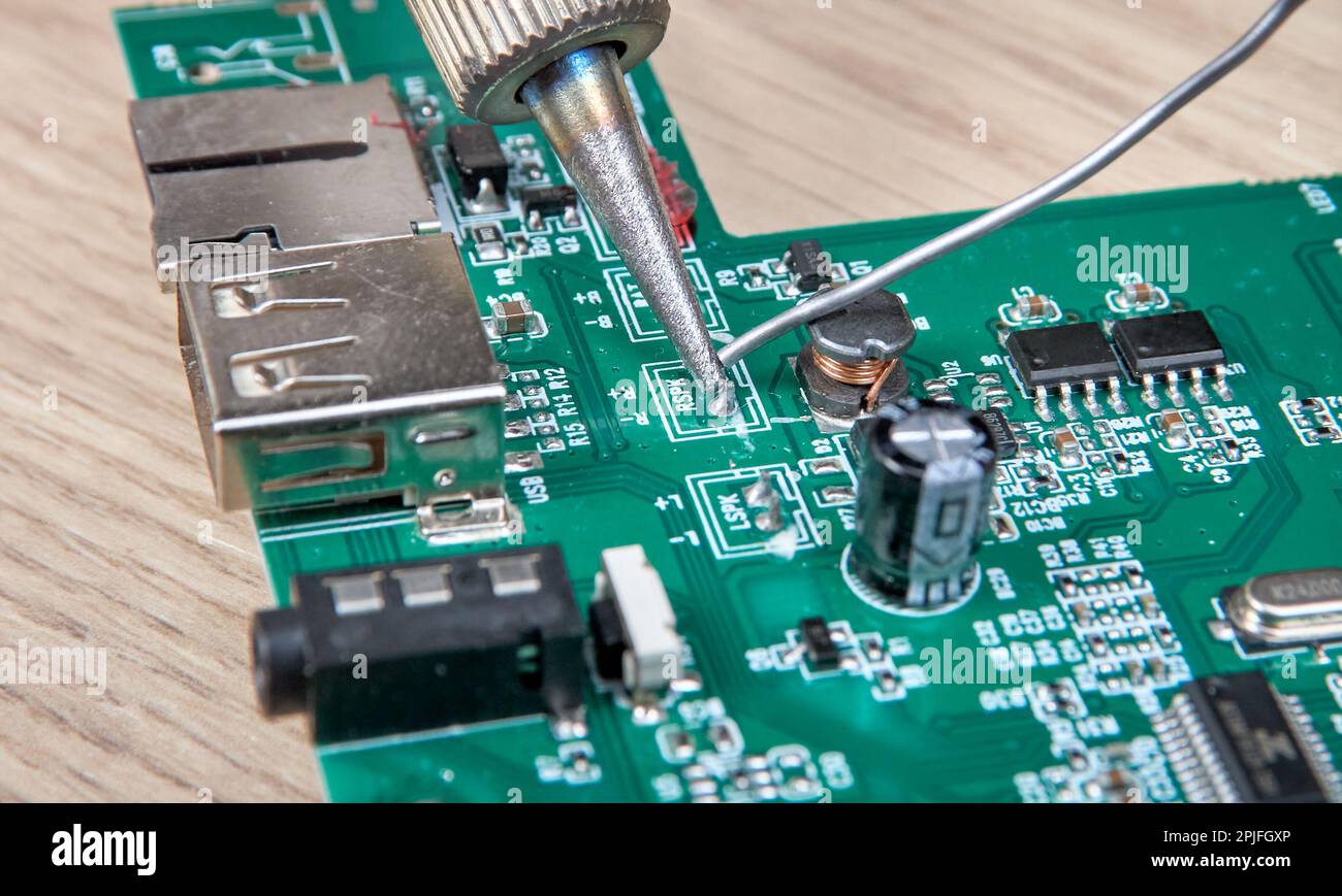 Repairing an electronic board with a soldering iron and tin wire Stock Photo - Alamy