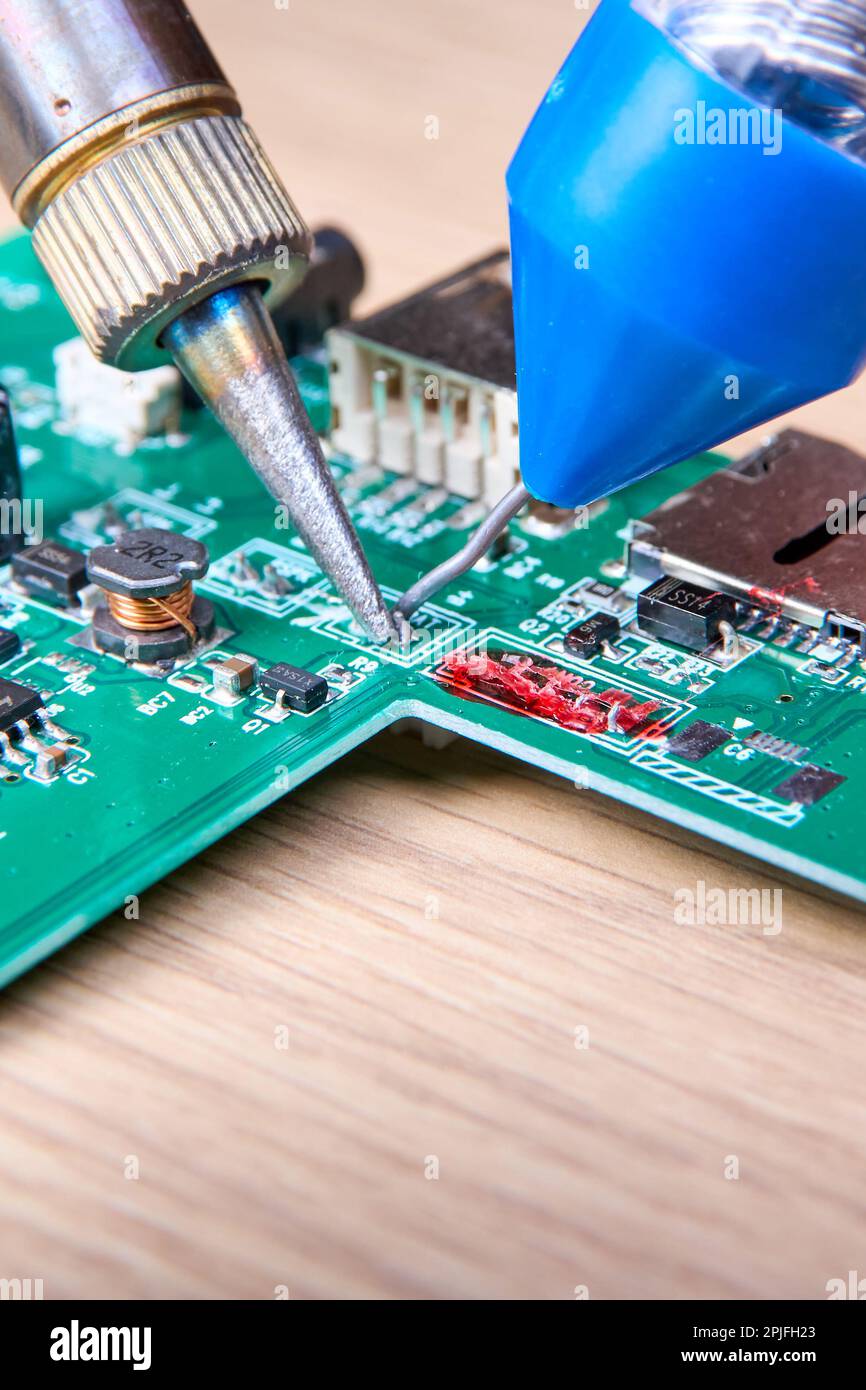 Repairing an electronic board with a soldering iron and tin wire Stock ...
