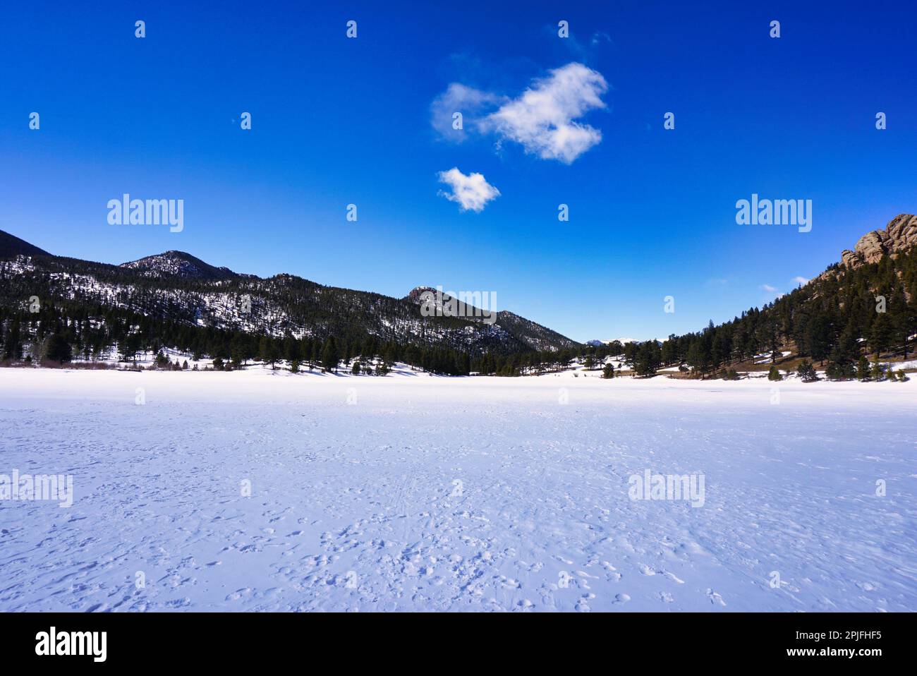 Frozen lake with mountains in the background, Rocky Mountains National ...