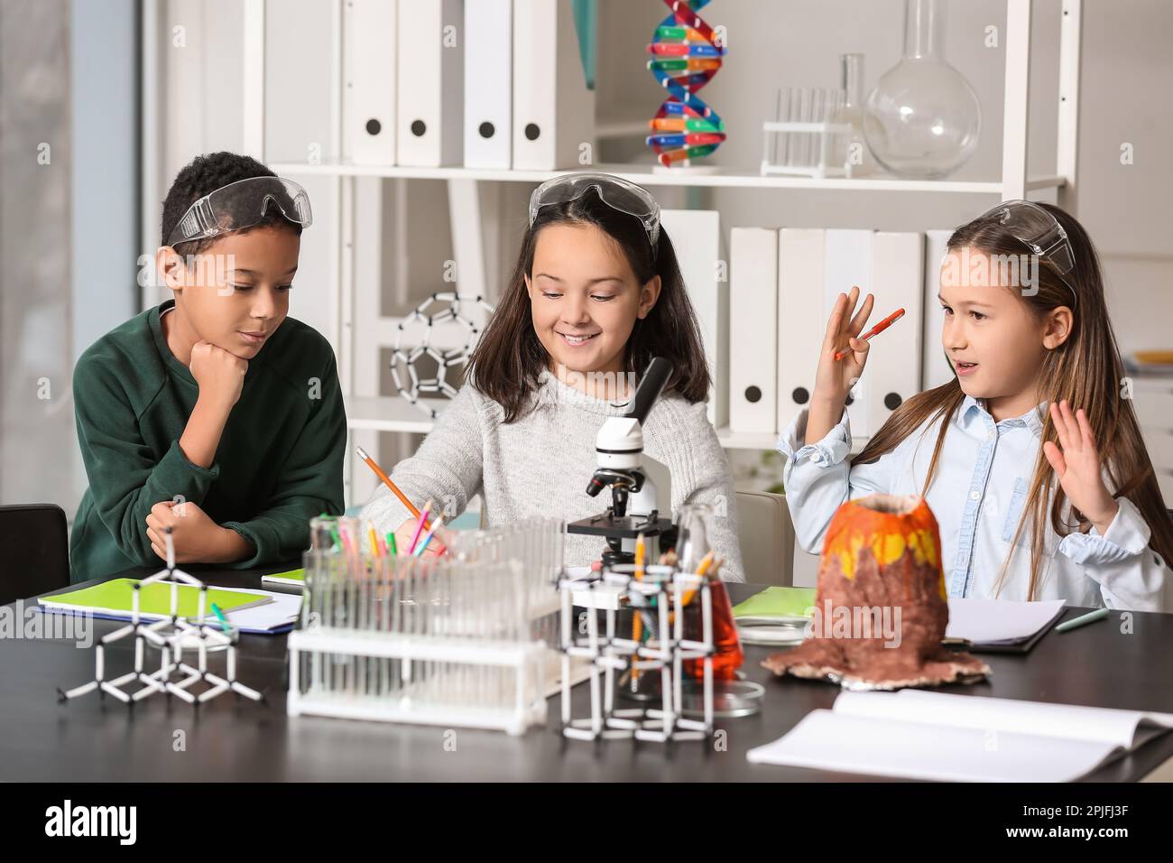 Cute little children with microscope in science classroom Stock Photo ...