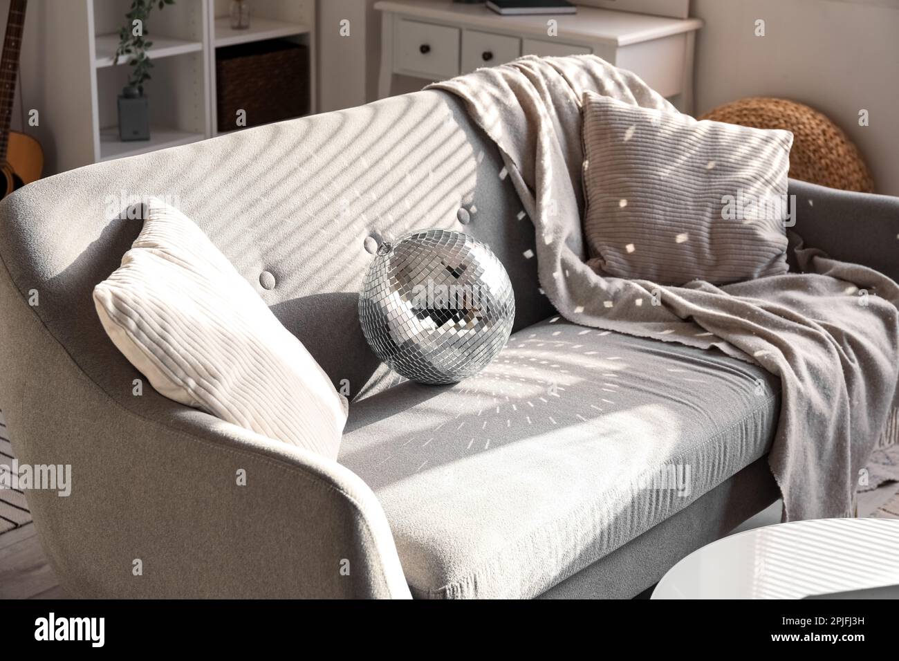 Disco ball on sofa in living room Stock Photo - Alamy