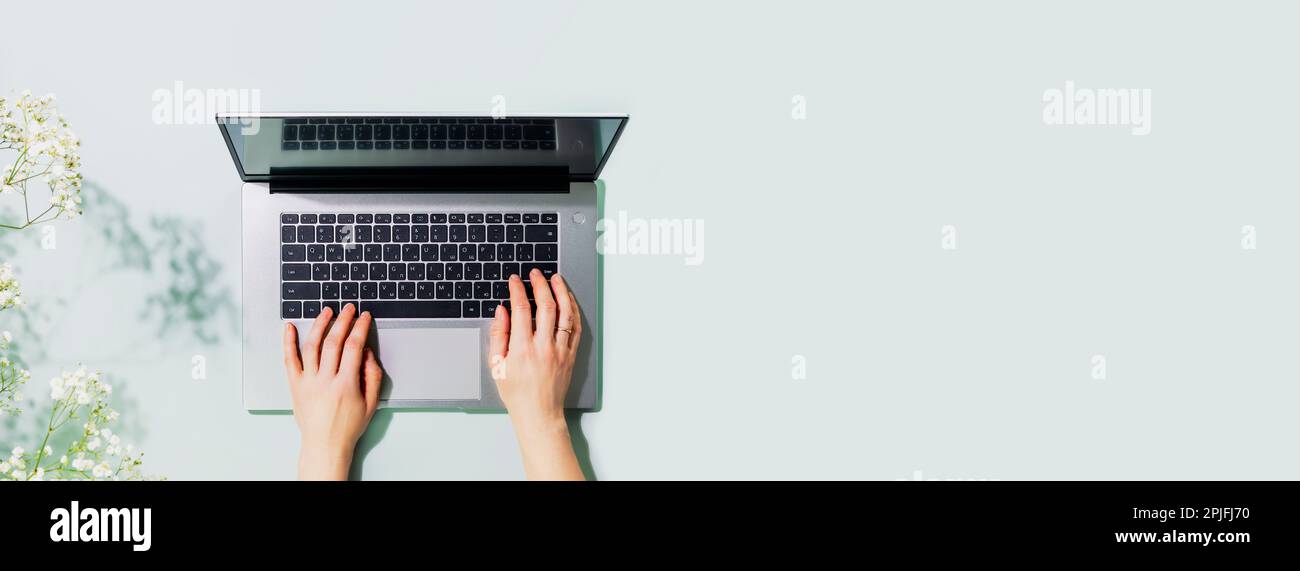 Romantic technology banner with womans hands working on laptop on blue ...