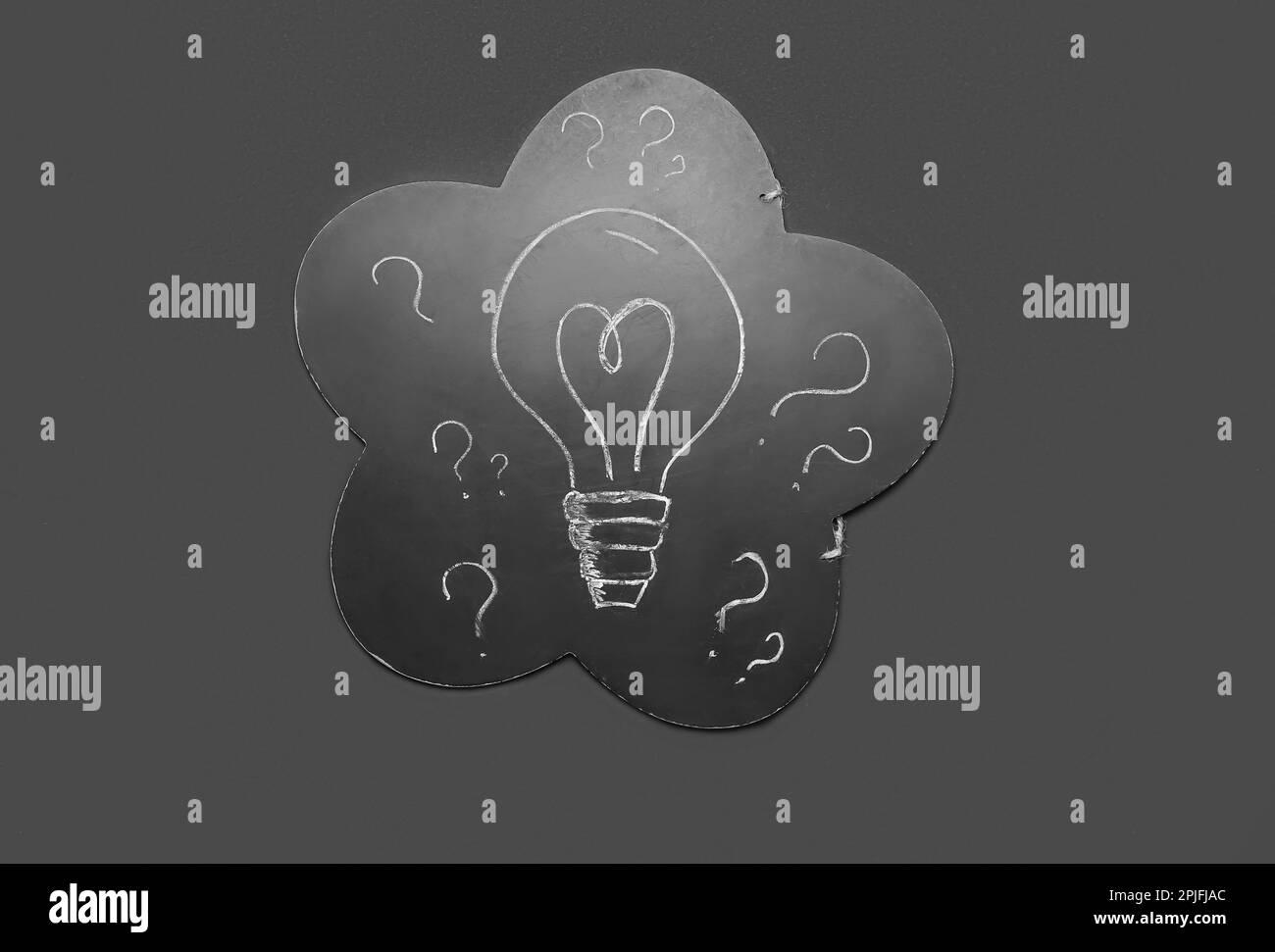 Chalkboard with drawn light bulb and question marks on black background ...