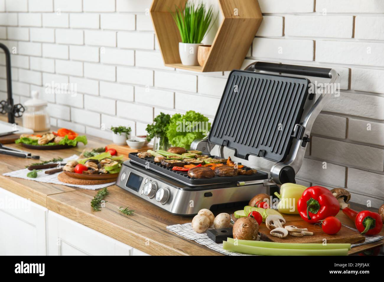 Modern electric grill with tasty vegetables on table in kitchen Stock ...