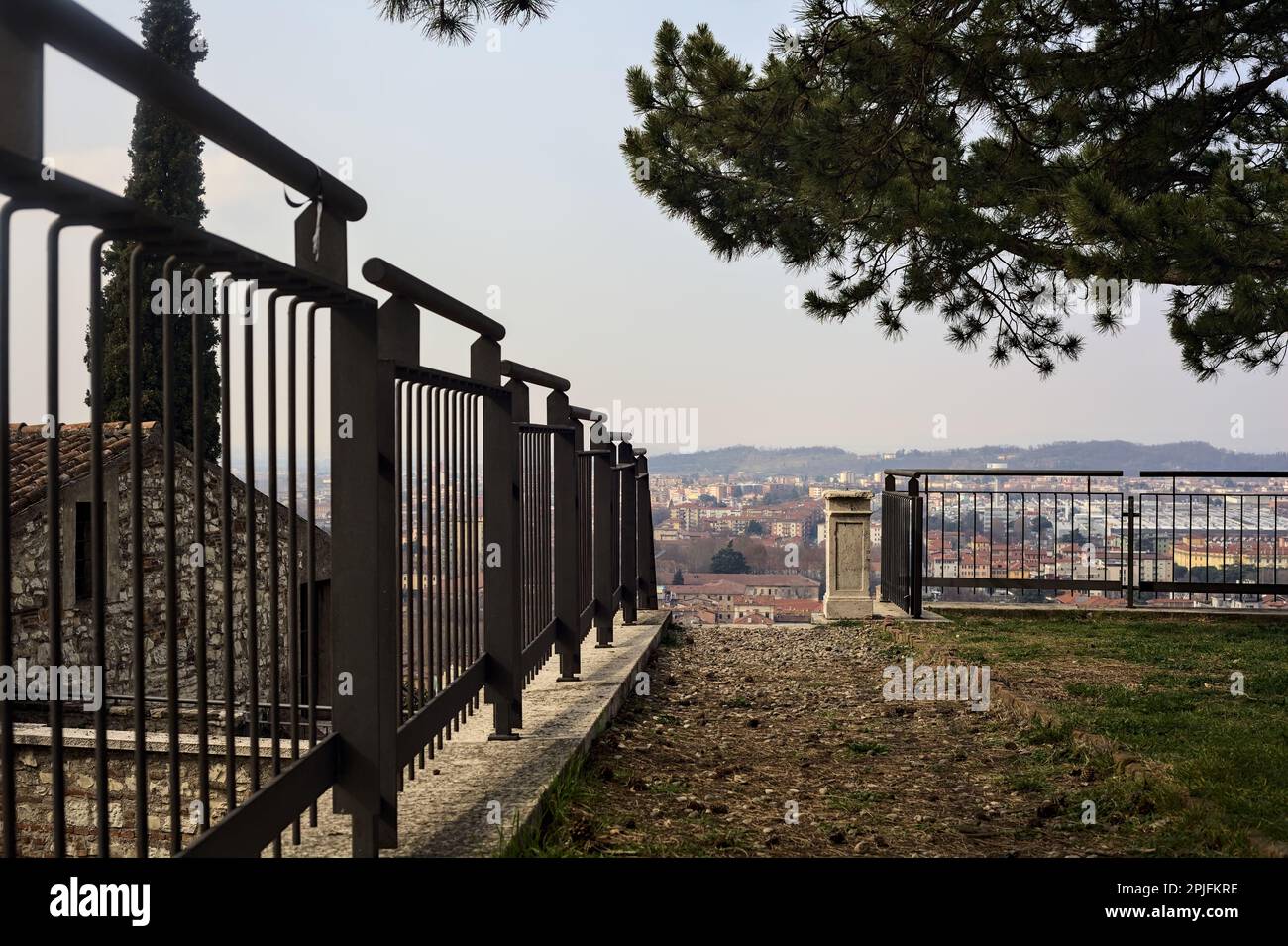 Balustrade next to trees in a park of a castle with a city seen from ...