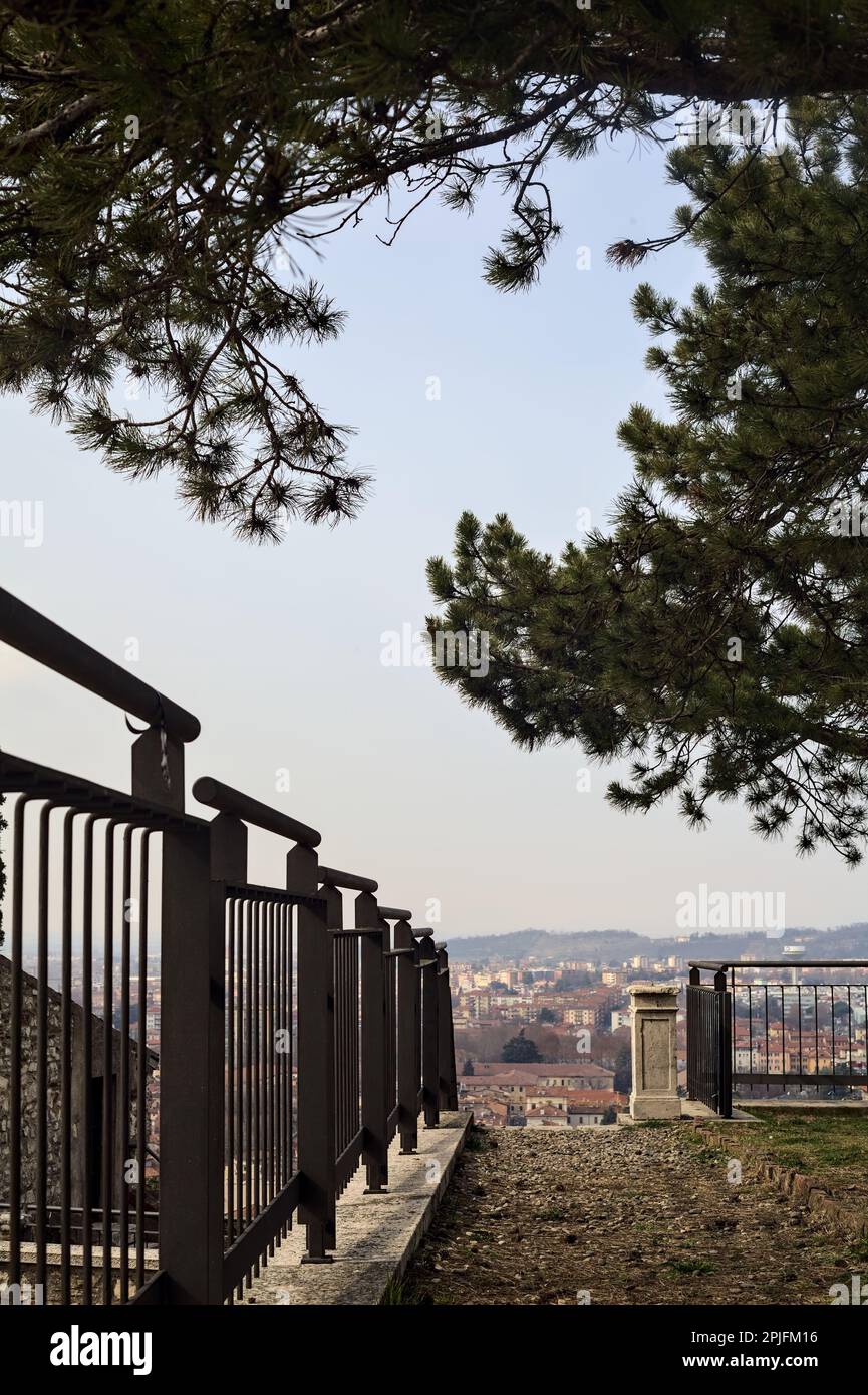 Balustrade next to trees in a park of a castle with a city seen from ...