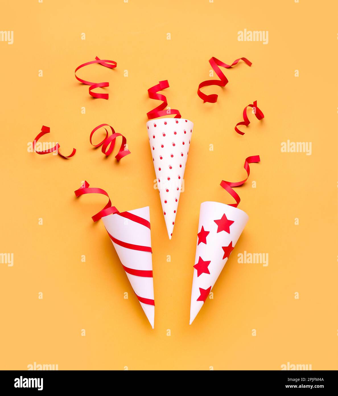 Party cones with serpentine on orange background Stock Photo - Alamy
